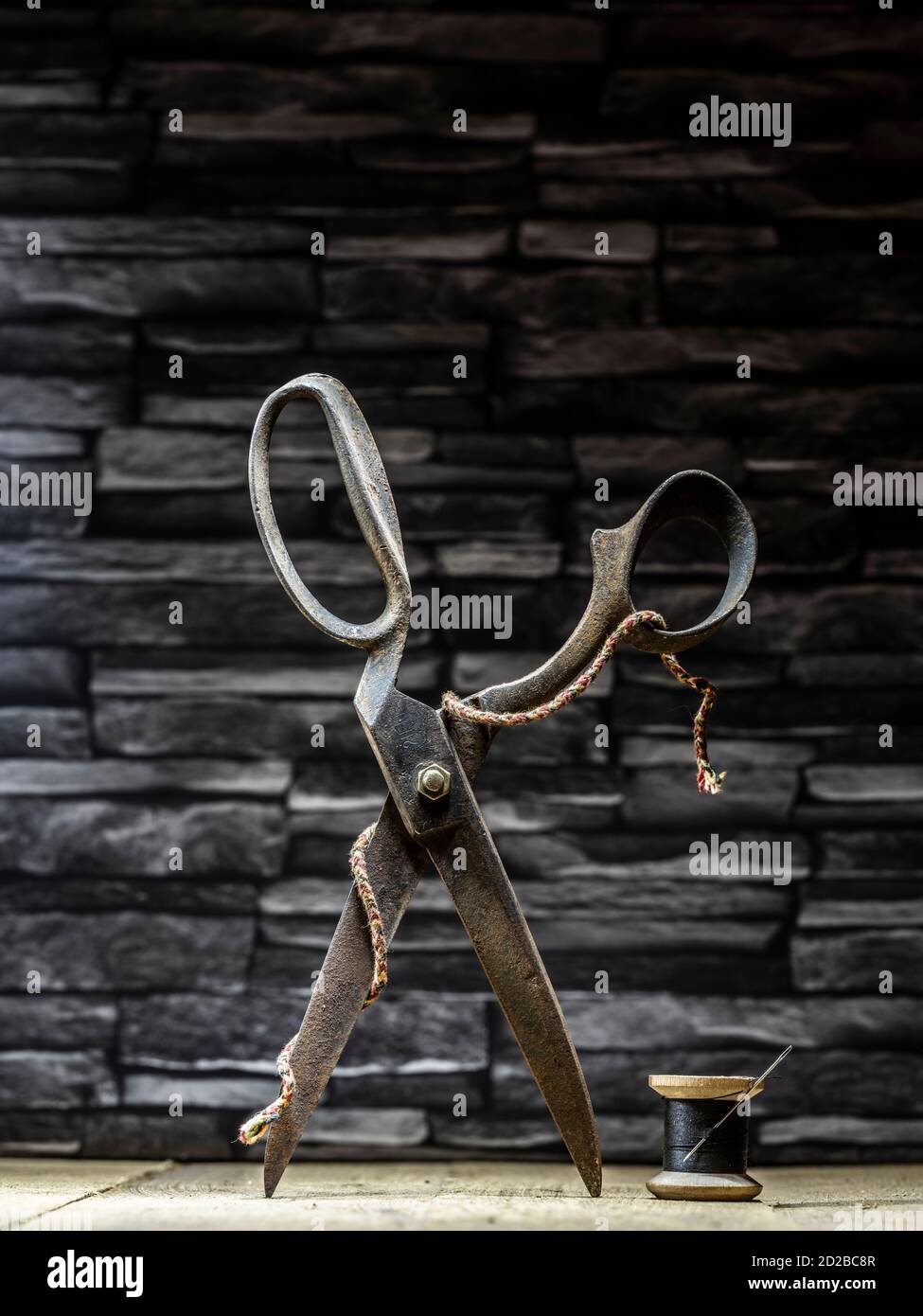 Rusty vintage pair of scissors balanced on timber flooring with black ...