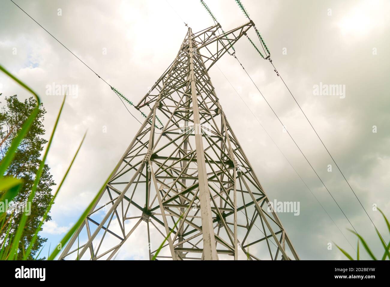 High-voltage power line against a cloudy sky with flashes of blue sky ...
