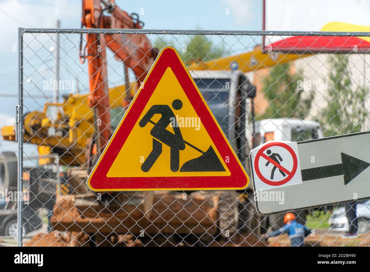 Road signs on a reconstructed street on a fenced grid on a summer Sunny ...