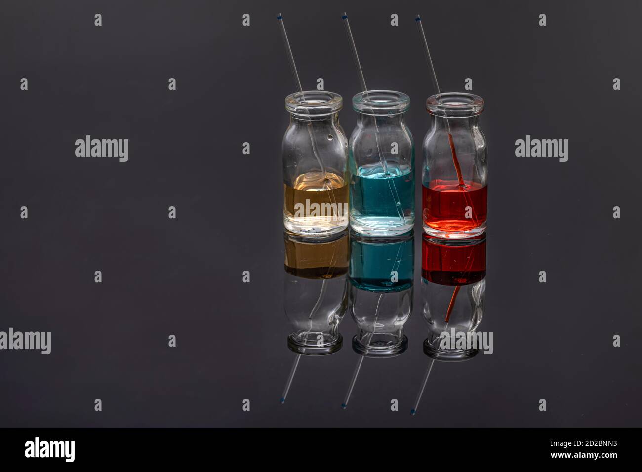 Glass vials with colored medicine liquid with capillaries. Red, yellow ...