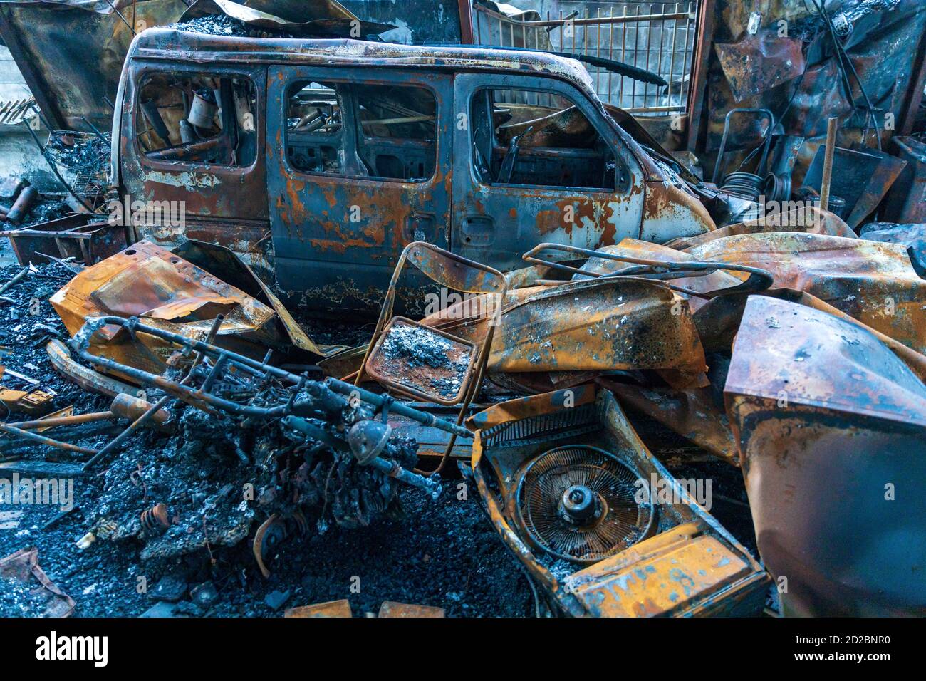 Twisted metal and burned out mini van after fire Stock Photo - Alamy
