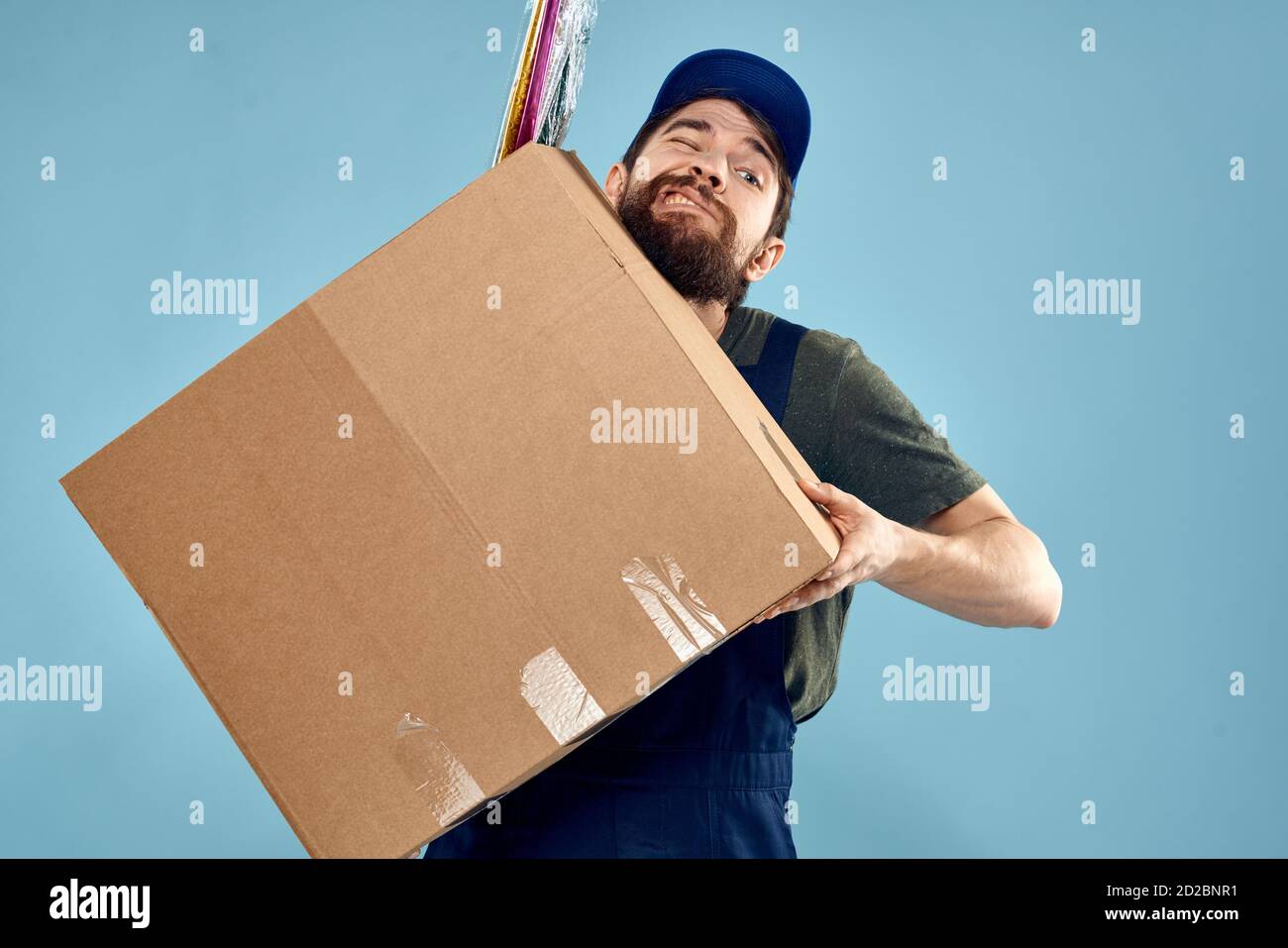 A man in working uniform with boxes in the hands of a carriage delivery ...