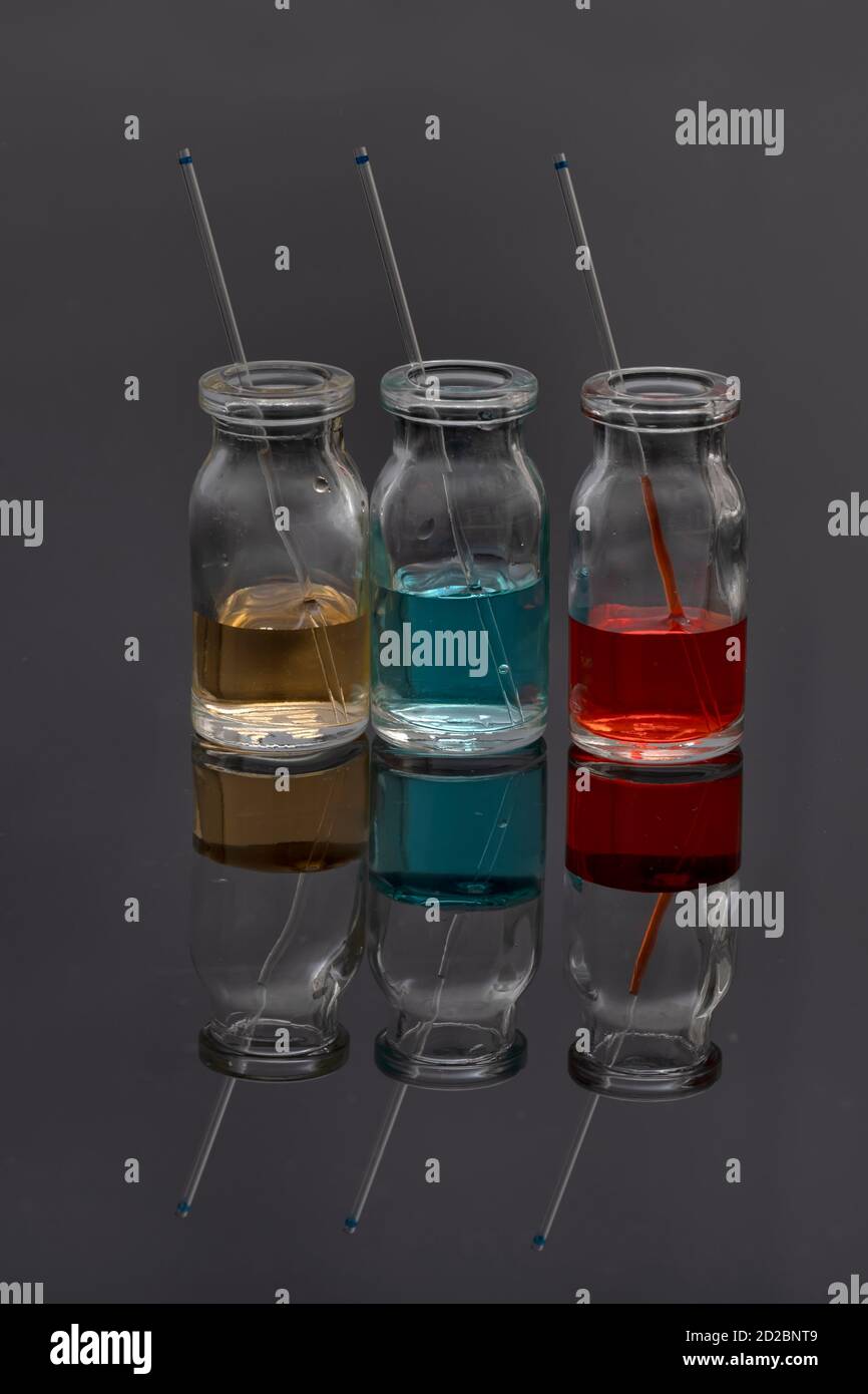 Glass vials with colored medicine liquid with capillaries. Red, yellow ...