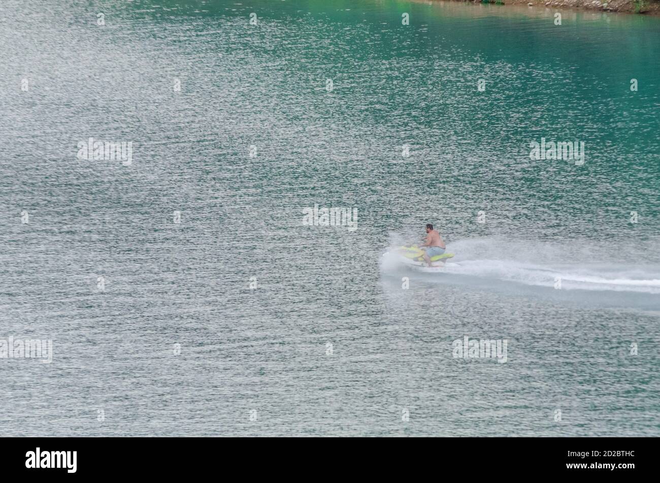 fat man on scooter raising clouds of spray in Sunny weather Stock Photo ...