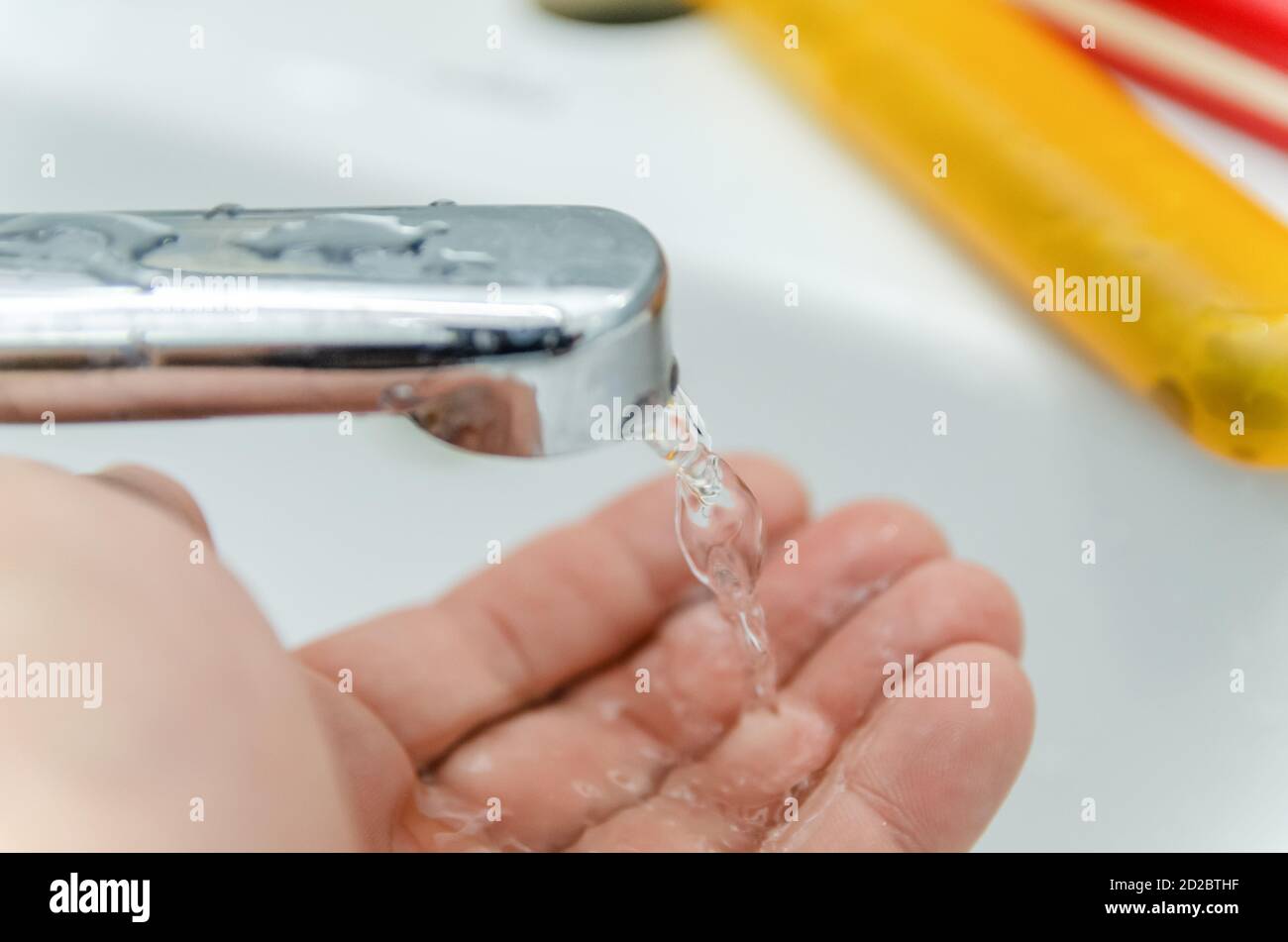 Male hand close-up under water tap in bathroom Stock Photo - Alamy