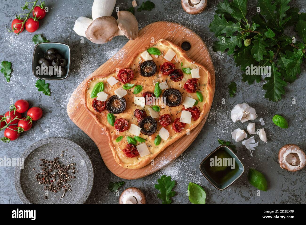 Pizza with tomatoes, mushrooms, and parmesan cheese in an irregular ...