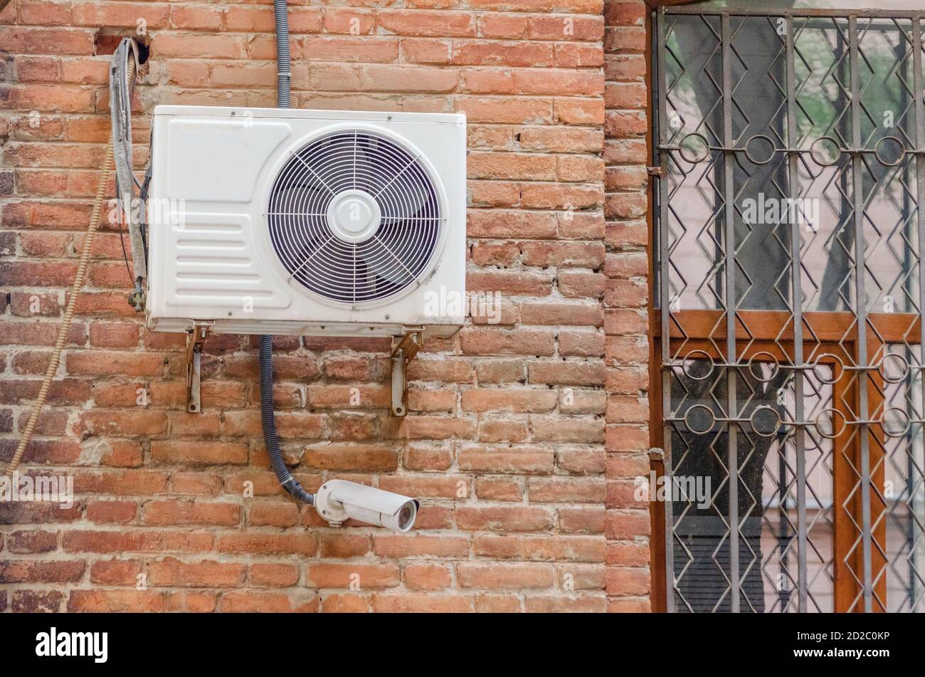 White air conditioning on the brick wall of the building near the ...