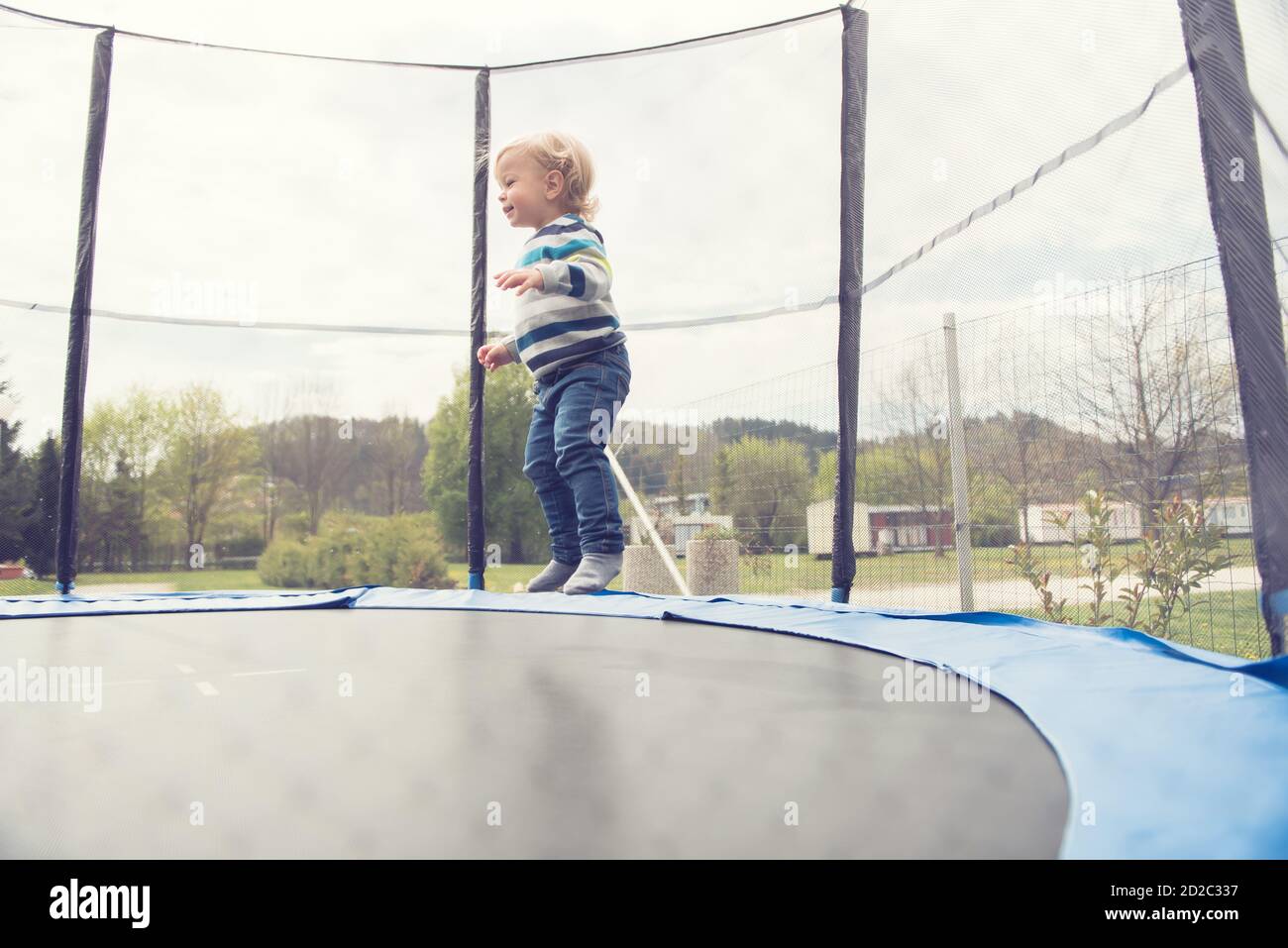 Beautiful little boy jumping on the trampoline outdoor Stock Photo - Alamy