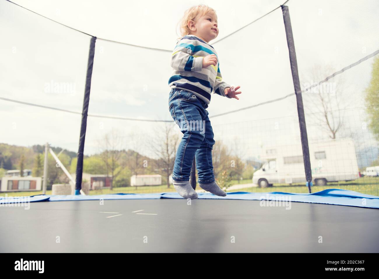 Beautiful little boy jumping on the trampoline outdoor Stock Photo - Alamy
