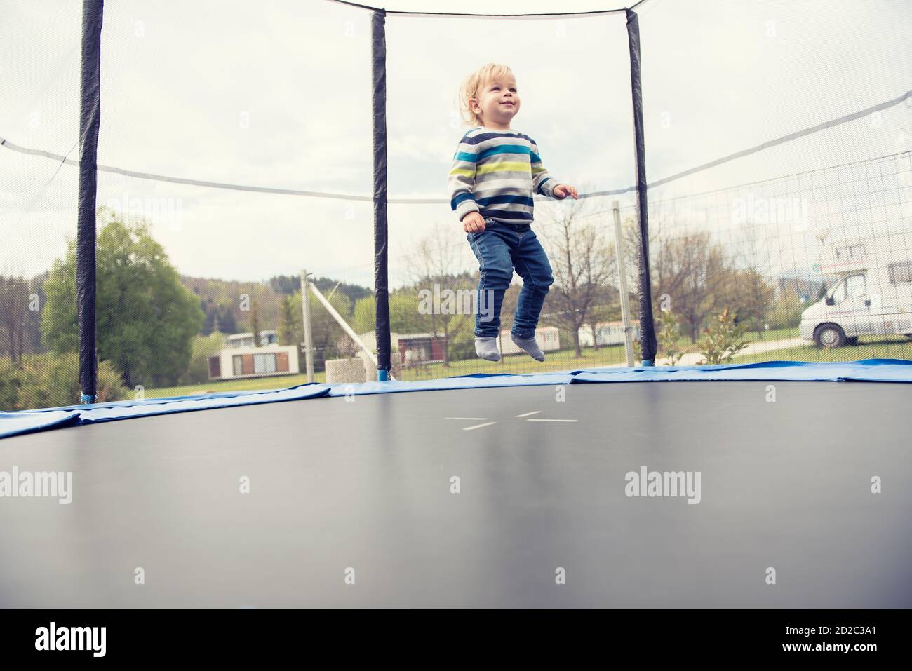 Beautiful little boy jumping on the trampoline outdoor Stock Photo - Alamy