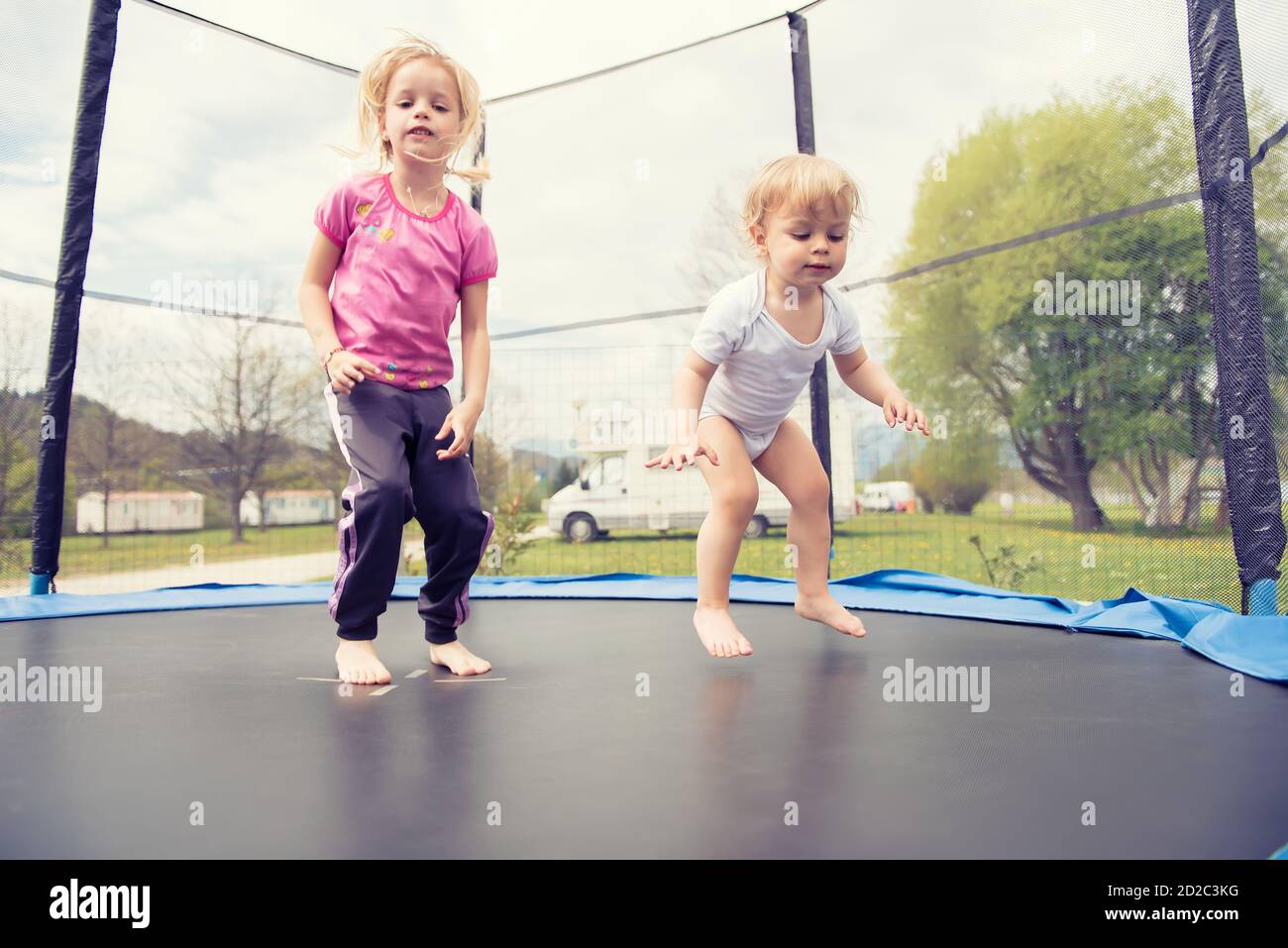 Two beautiful kids jumping on the trampoline and enjoying Stock Photo ...