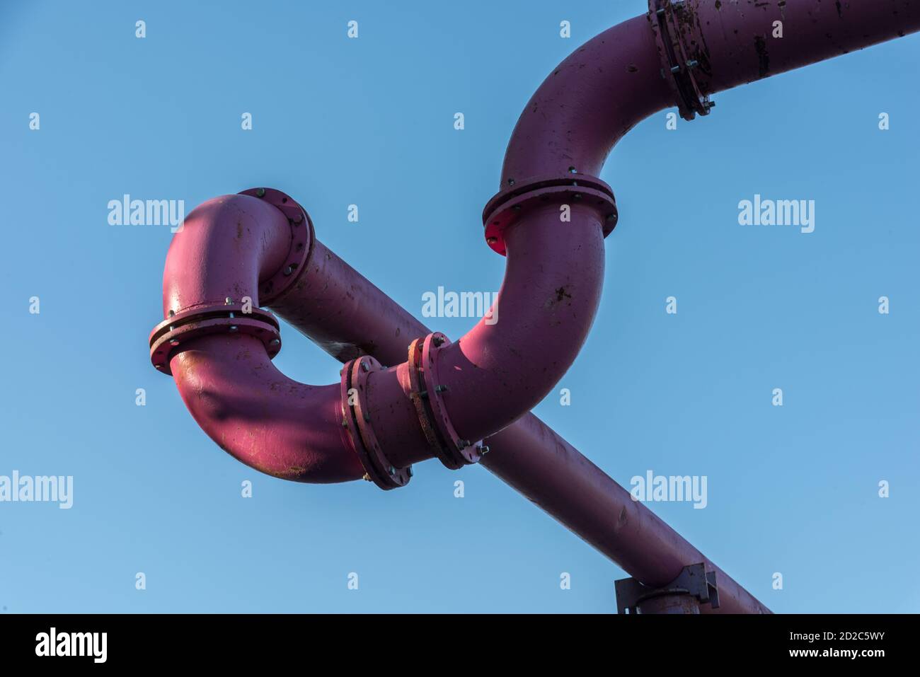 Pink steel pipes for draining water with blue sky Stock Photo - Alamy