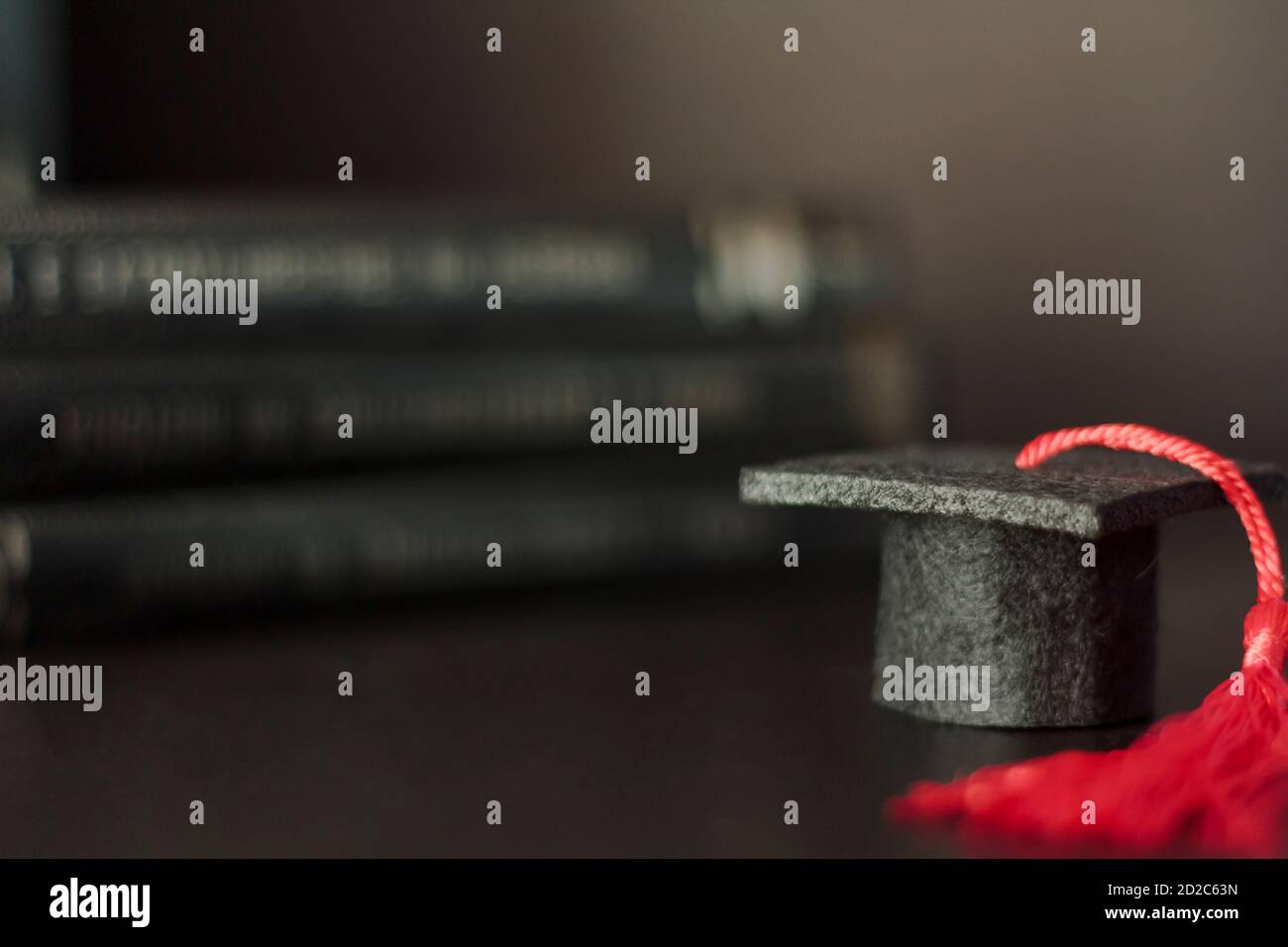 Graduation cap with books on the background. Education and Graduation ...