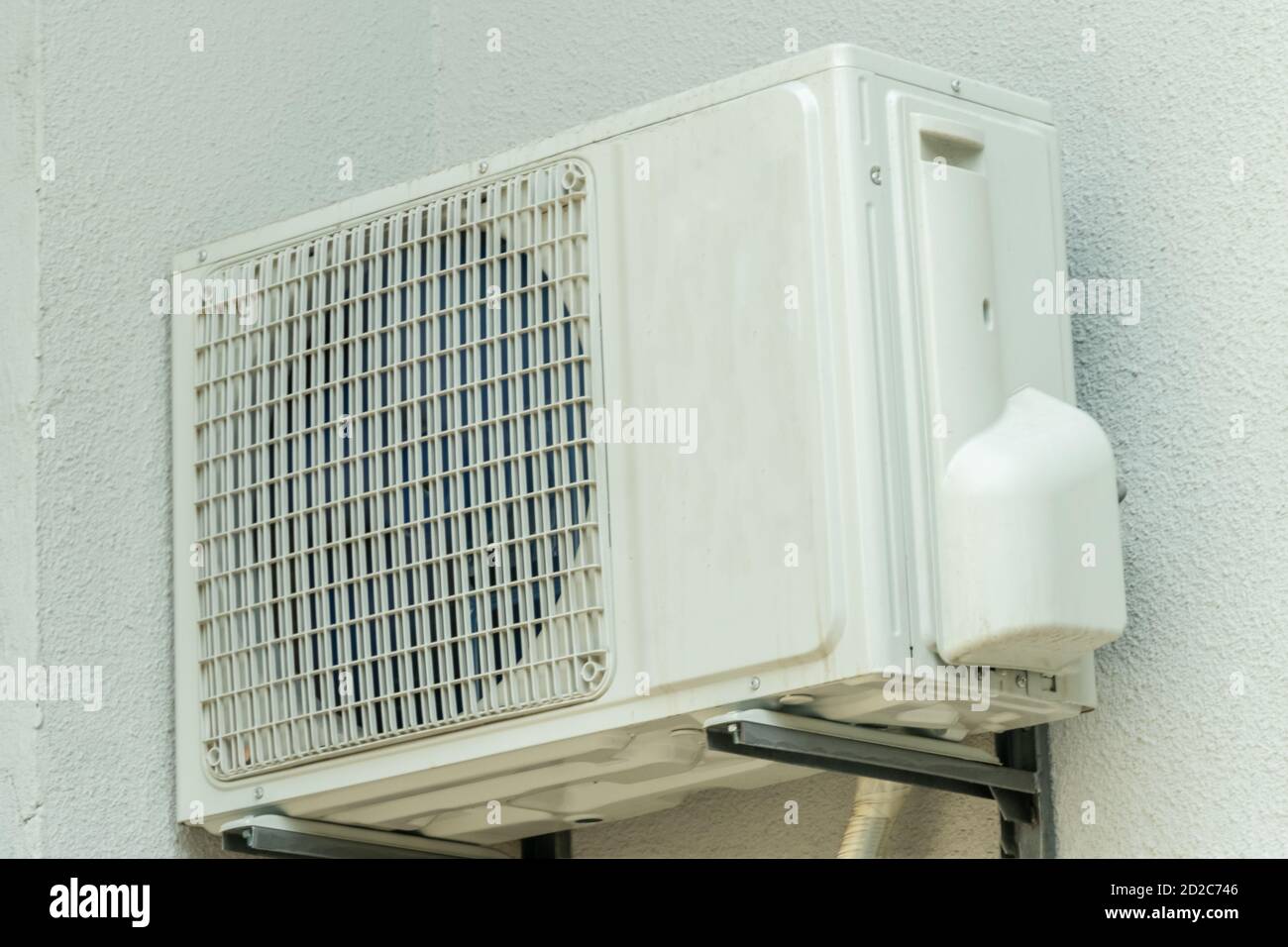 Old white air conditioner mounted outside on a white wall close up ...