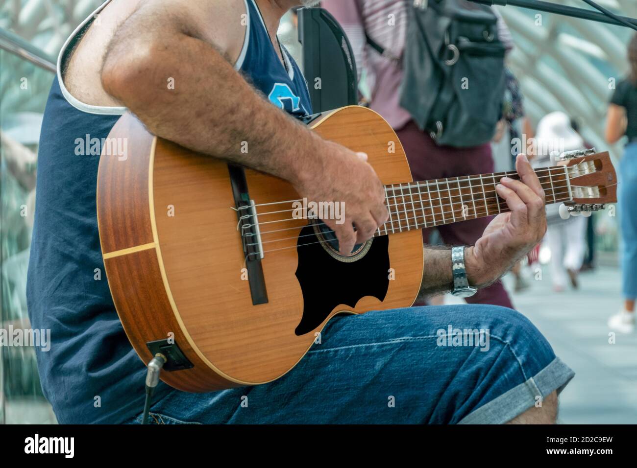 A man plays the guitar. Outdoor street portrait. No face, close up ...