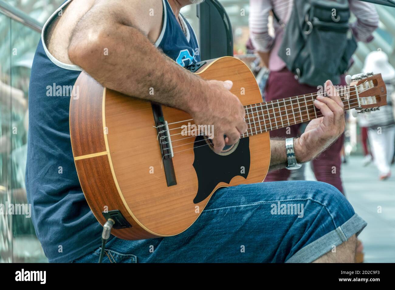 A man plays the guitar. Outdoor street portrait. No face, close up ...