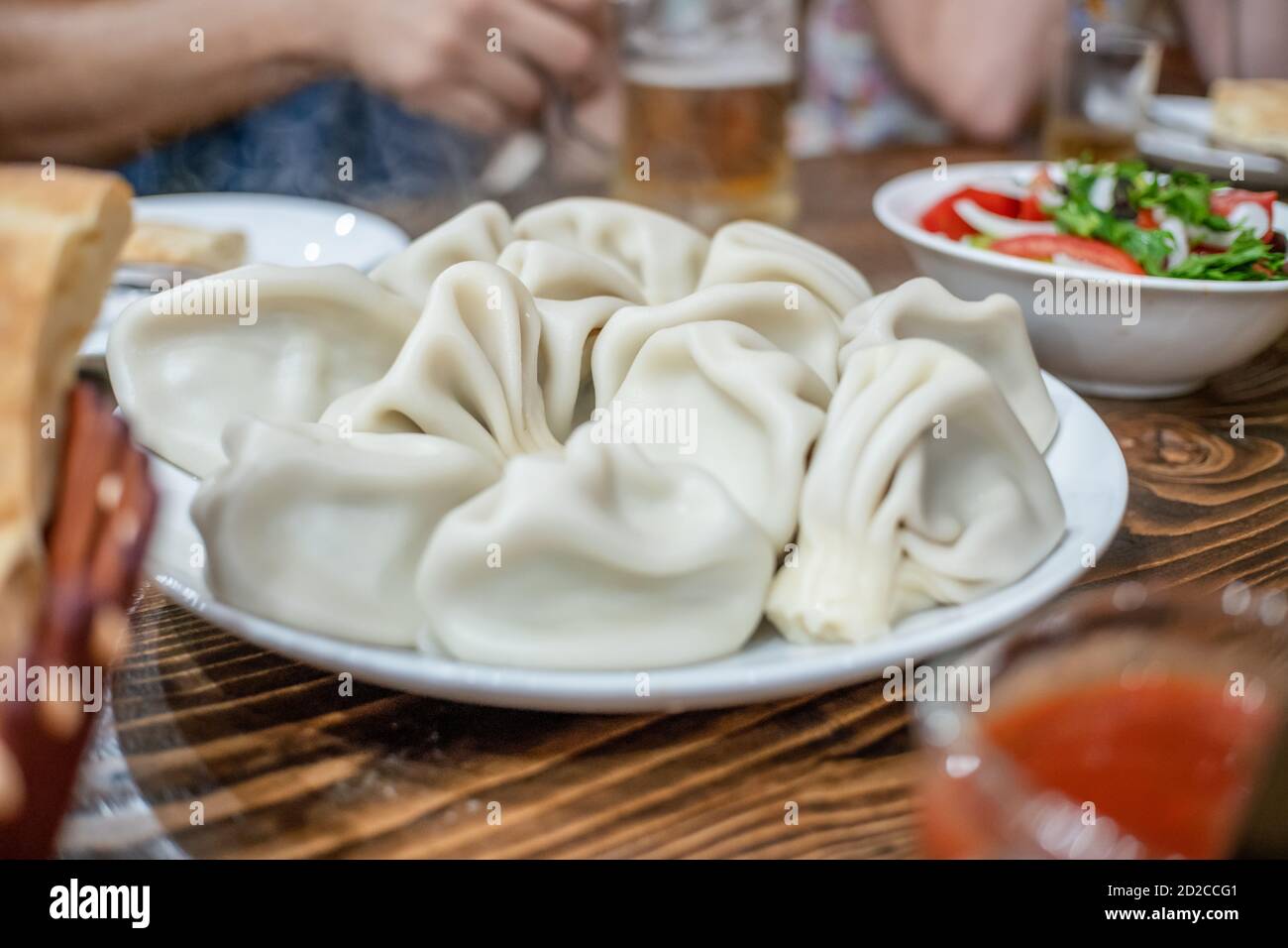 Top view of traditional Georgian lunch: khinkali, bread, vegetable ...