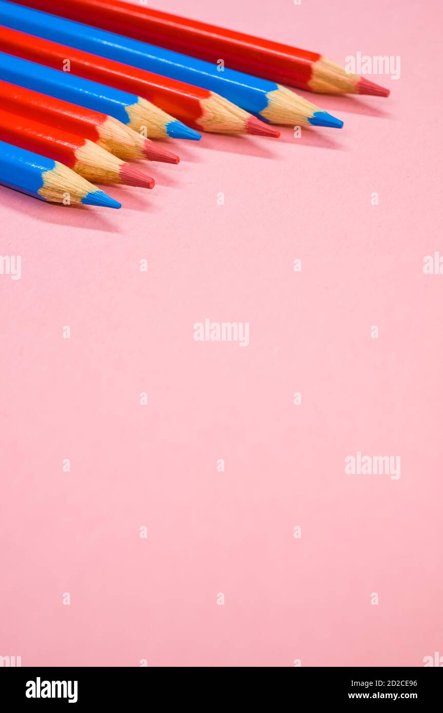 Vertical shot of red and blue pencils on a pink surface Stock Photo - Alamy
