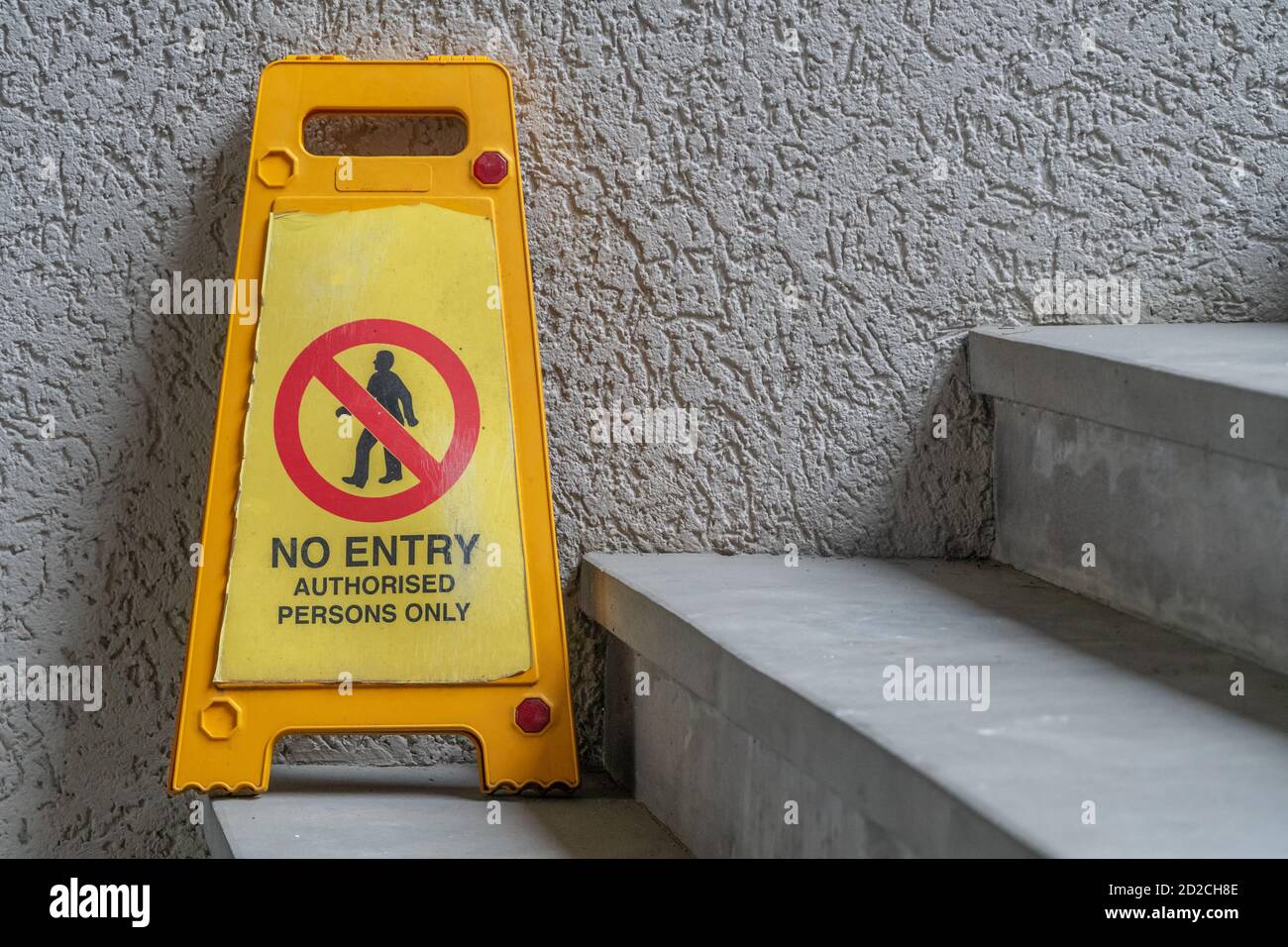 yellow sign "no entry. authorised persons only" close-up on the steps ...