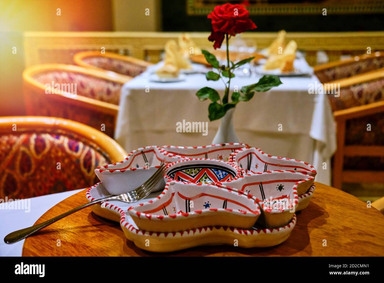 Table with a plate in the Arab style and a flower. Arab cafe in Tunisia ...