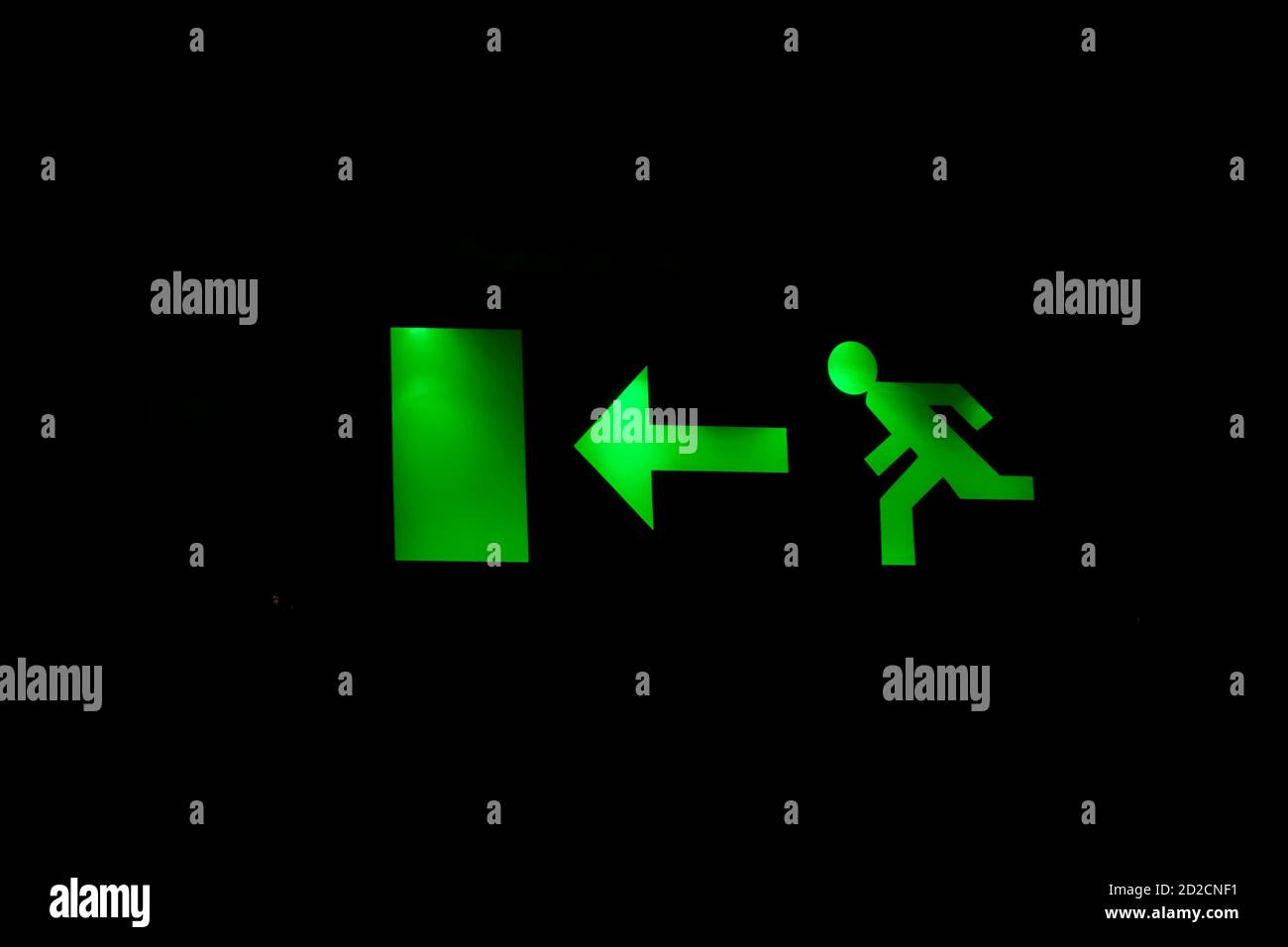 Green sign "exit there" glows in the dark close up Stock Photo - Alamy