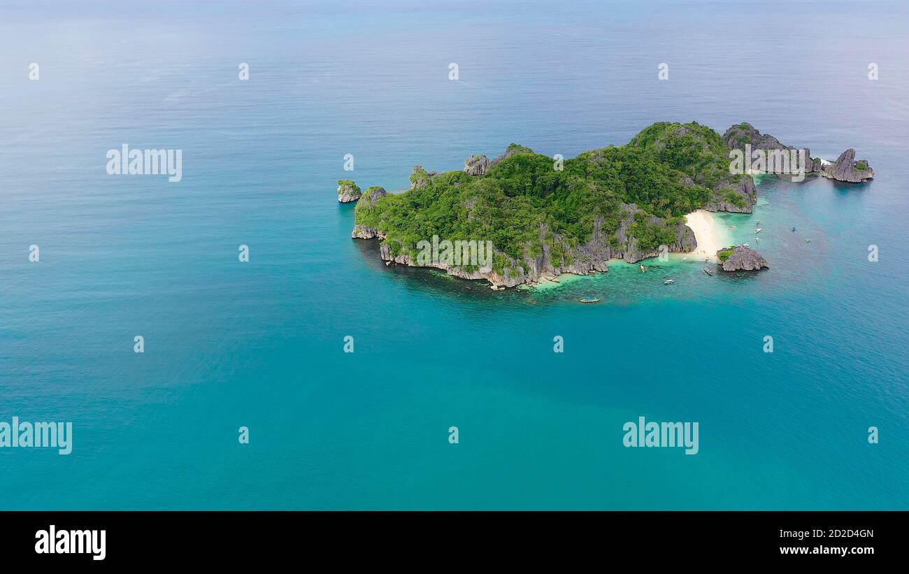 Tropical beach with tourists surrounded by blue water, aerial view ...
