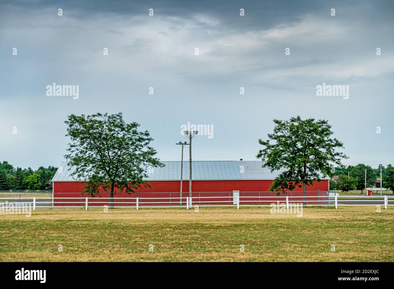 Red metal shed and white rail fence Stock Photo - Alamy