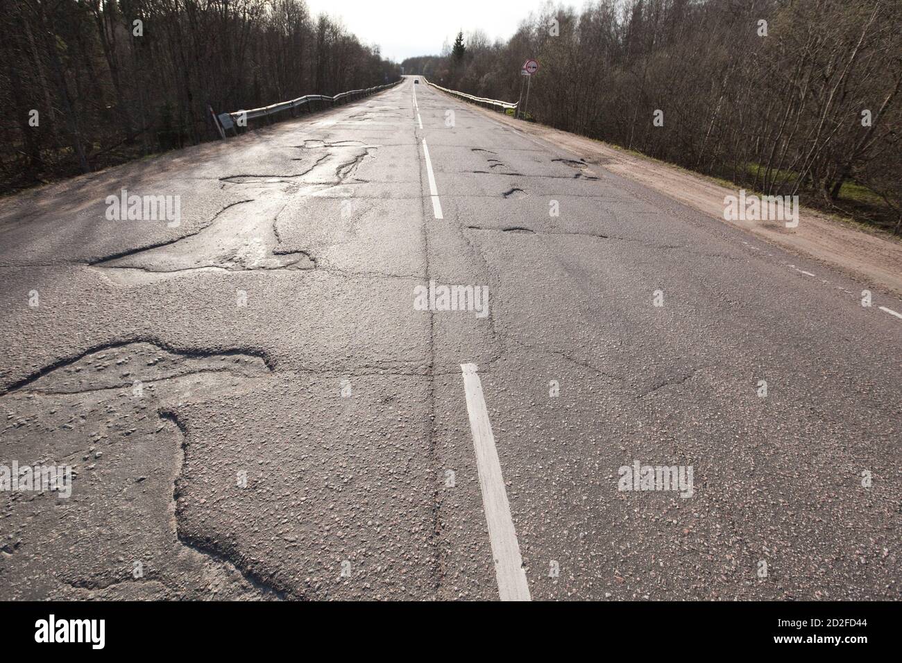 Bad quality road with potholes. Hole in asphalt. Pit, unsafe, hole road ...