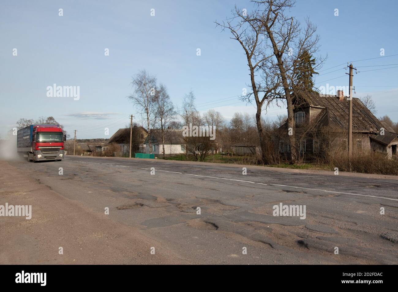 Bad quality road with potholes, truck on background, countryside. Hole ...