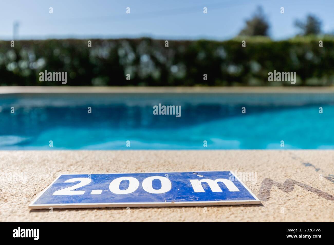 blue plastic plate at the edge of a swimming pool indicating a depth of ...