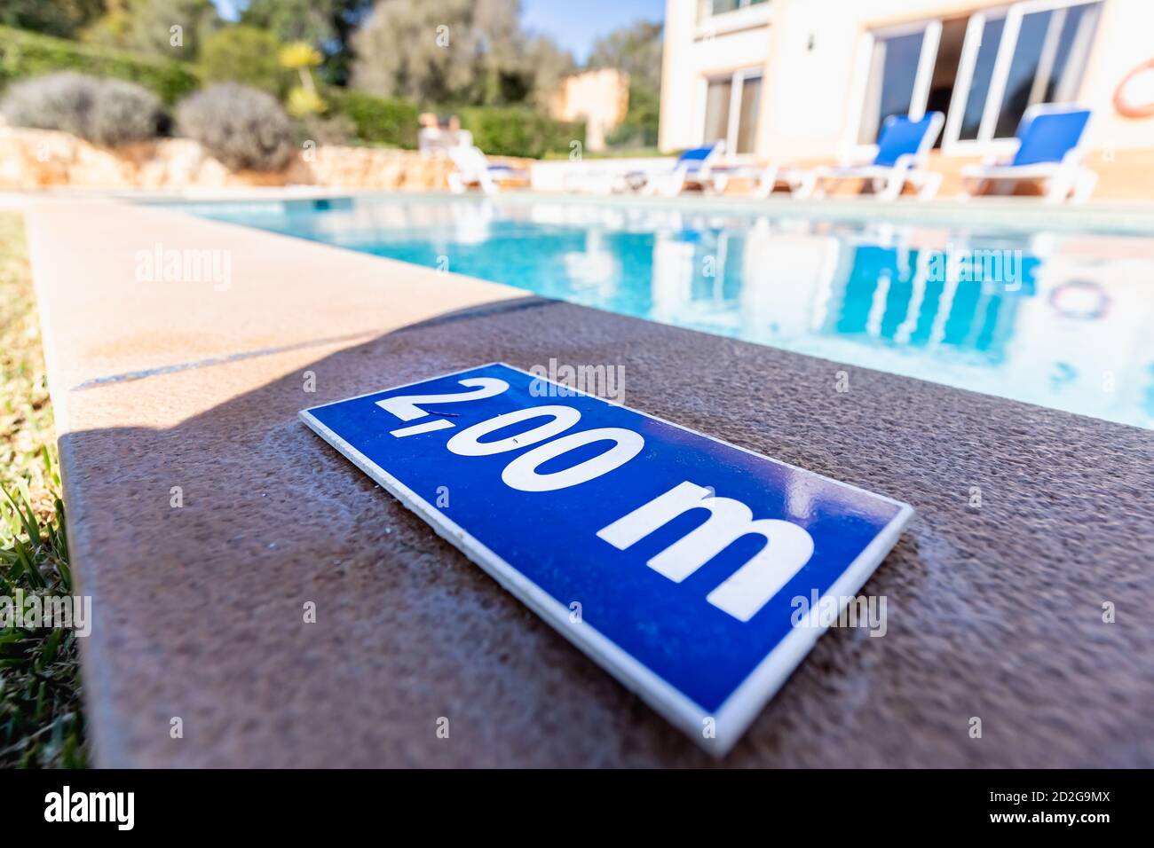 blue plastic plate at the edge of a swimming pool indicating a depth of ...