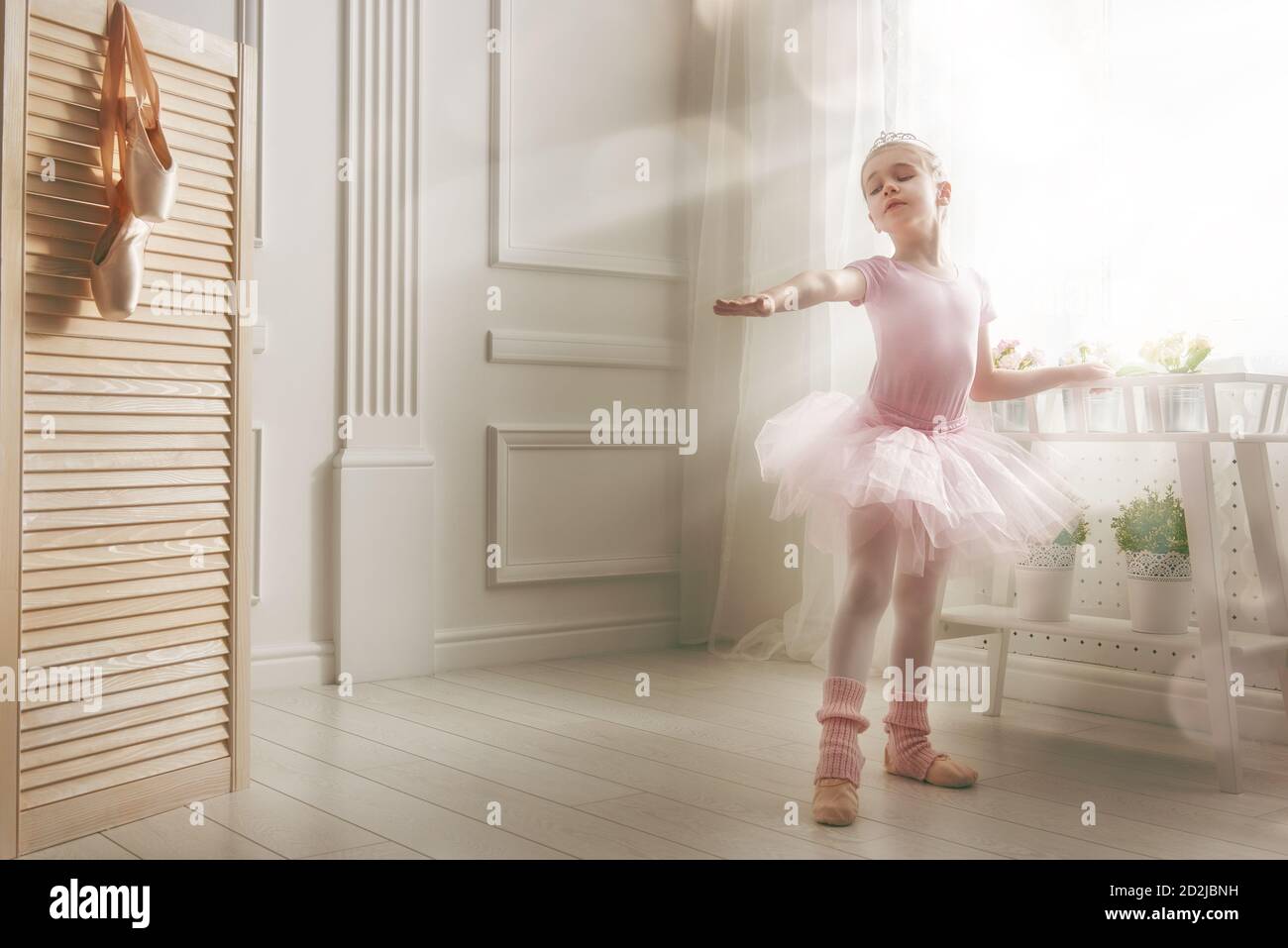 Cute little girl dreams of becoming a ballerina. Child girl in a pink ...