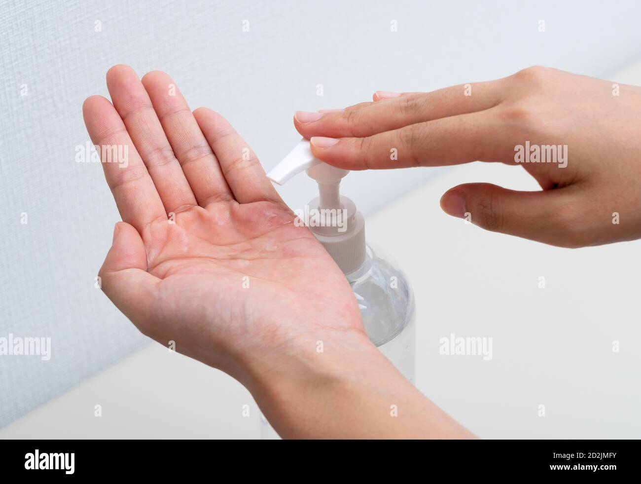 Women's hands using sanitizing gel Stock Photo - Alamy