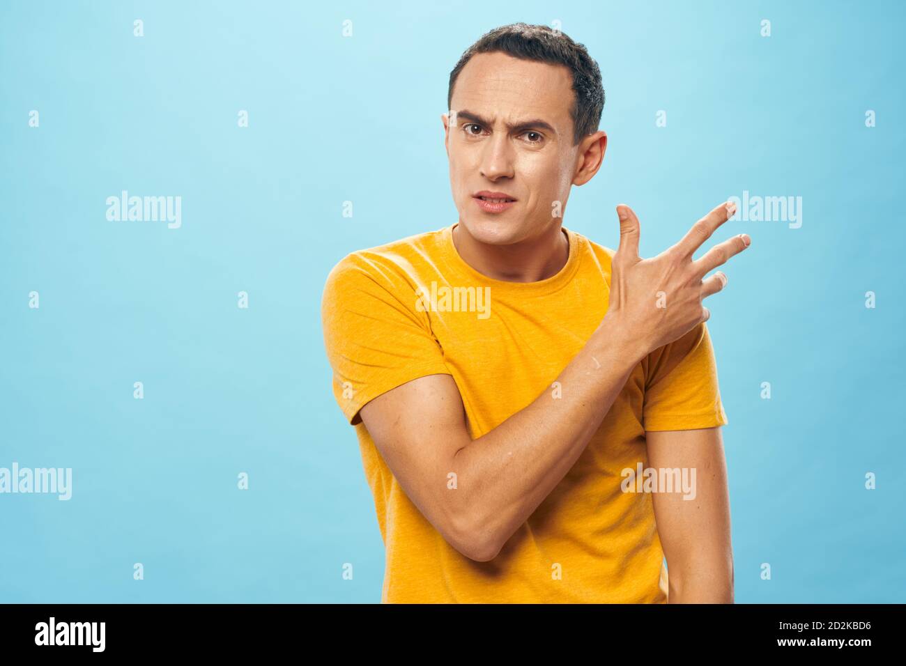 An indignant man gestures with his hands on a blue background Stock ...