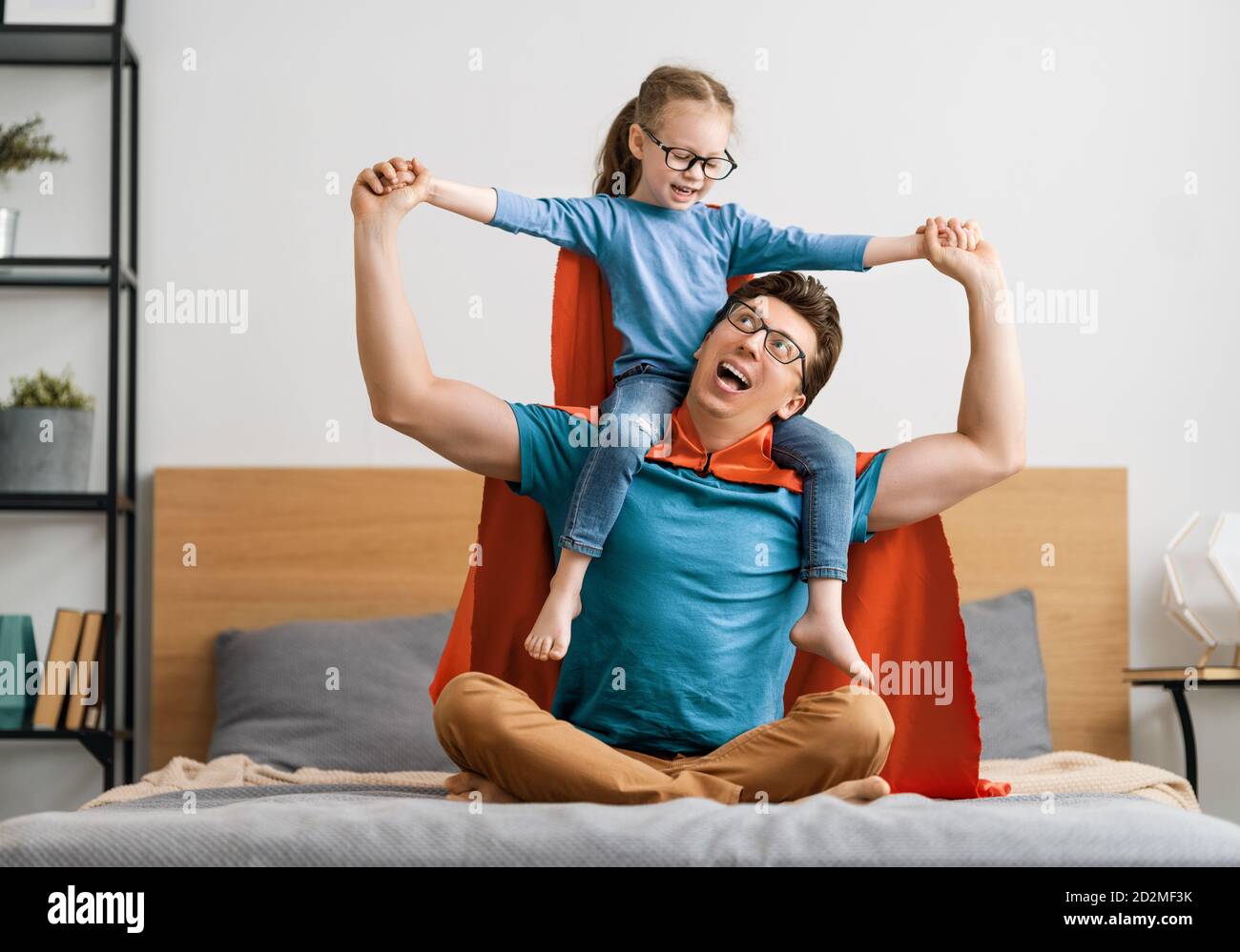 Father and his child playing together. Girl and dad in Superhero ...