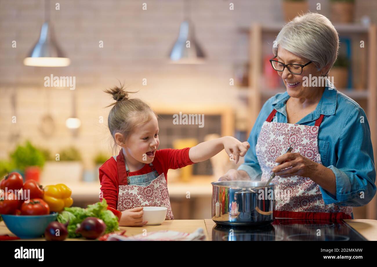 Healthy food at home. Happy family in the kitchen. Grandma and child ...