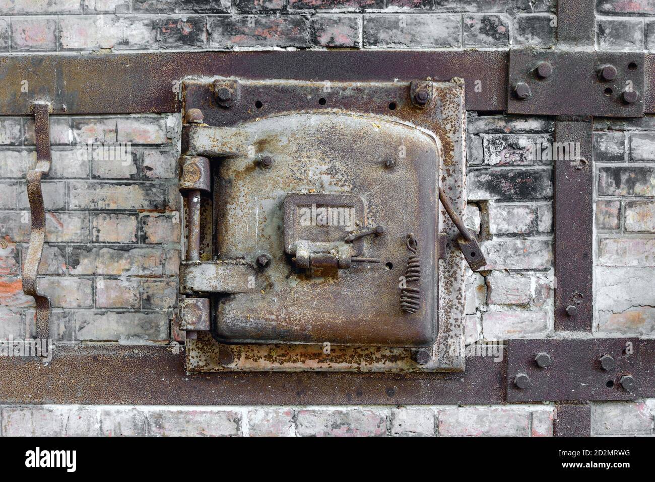 Rusty old metal hatch door of a red brick kiln in an abandoned factory ...