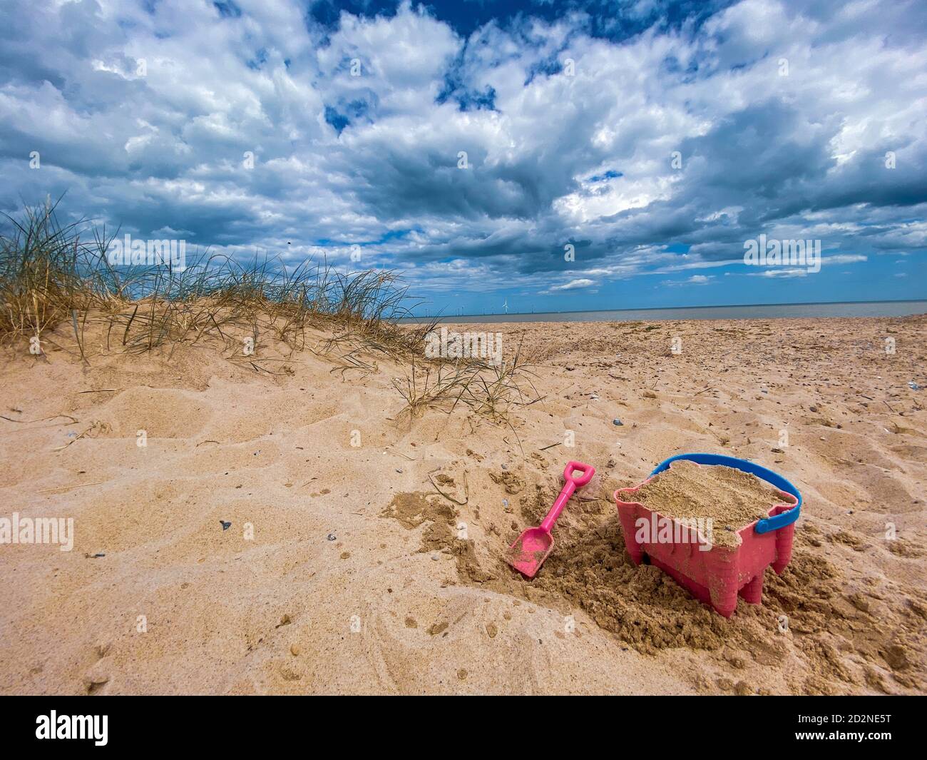 Pink Basket and spade on Great Yarmouth beach in a cold summer day ...
