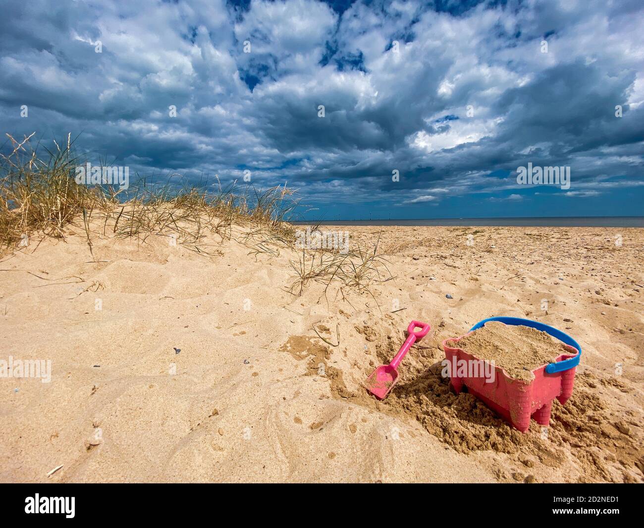 Pink Basket and spade on Great Yarmouth beach in a cold summer day ...