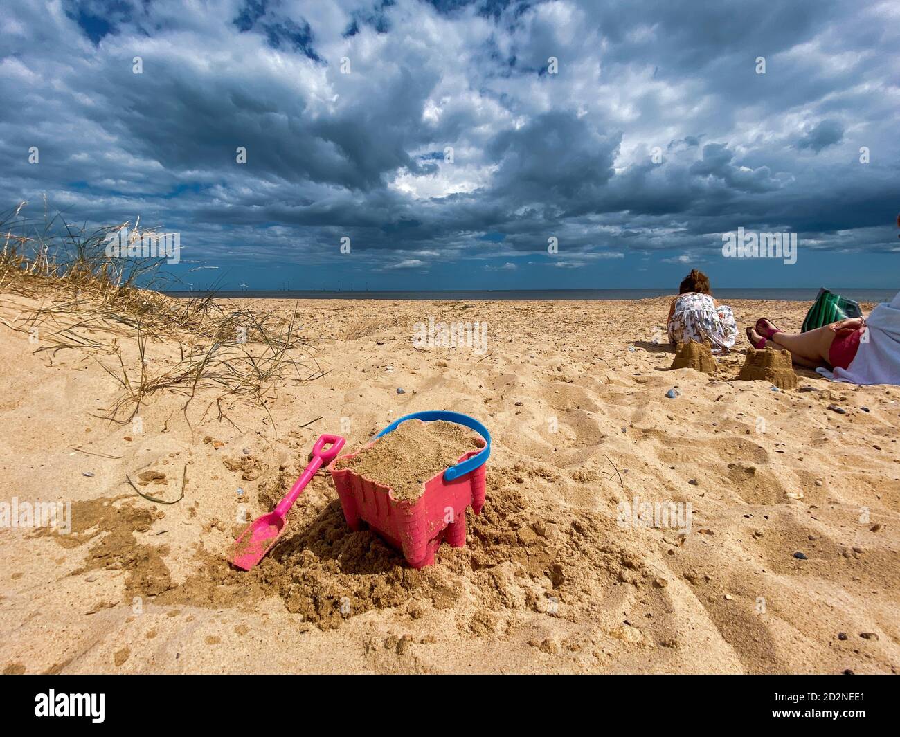 Pink Basket and spade on Great Yarmouth beach in a cold summer day ...