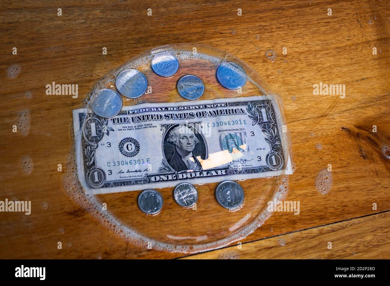 A one dollar bill and coins, all covered by a big bubble Stock Photo ...