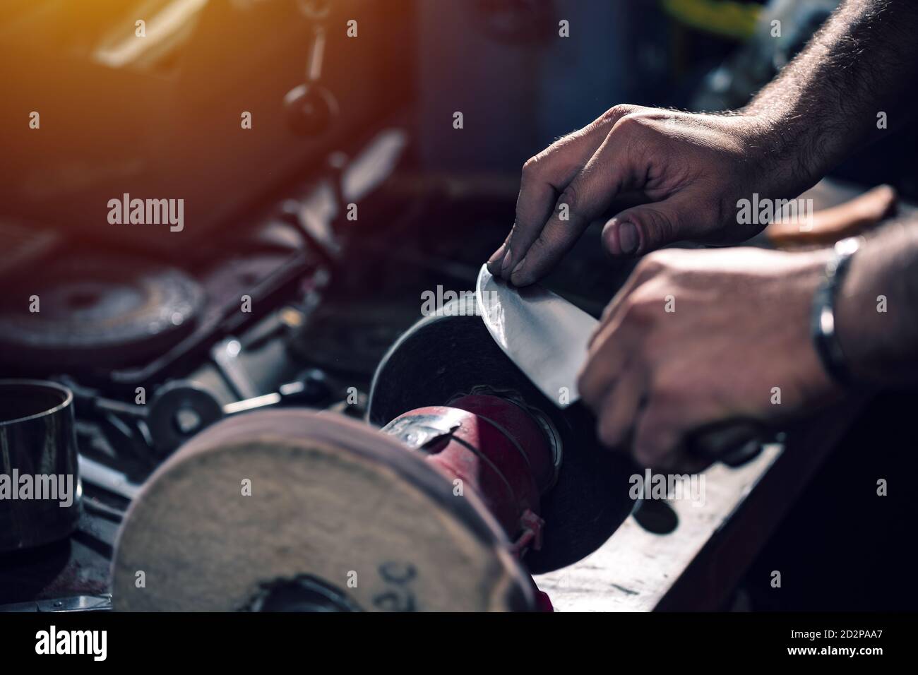 Man hand sharpens knife on grindstone, close up shot Stock Photo - Alamy