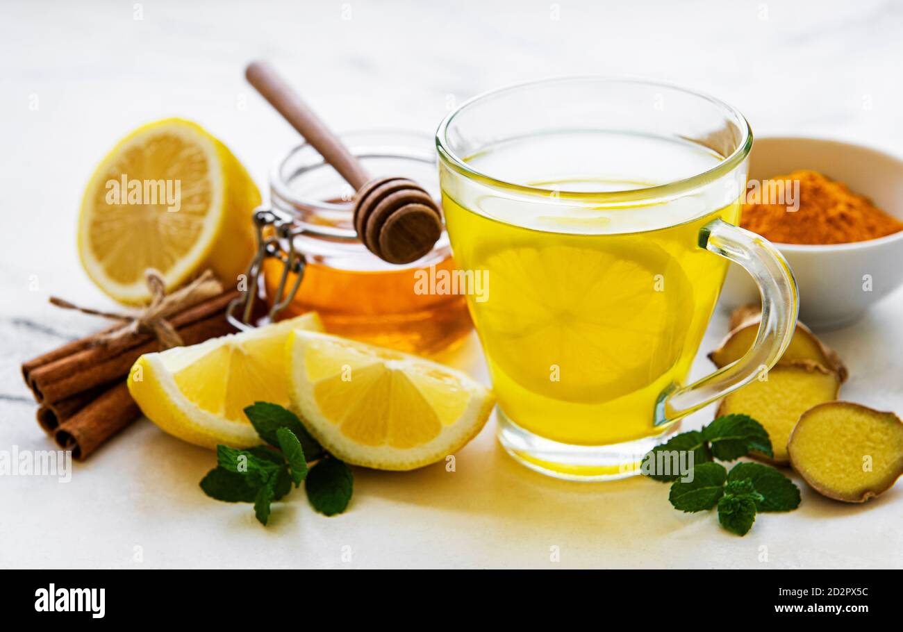 Energy tonic drink with turmeric, ginger, lemon and honey on a white ...