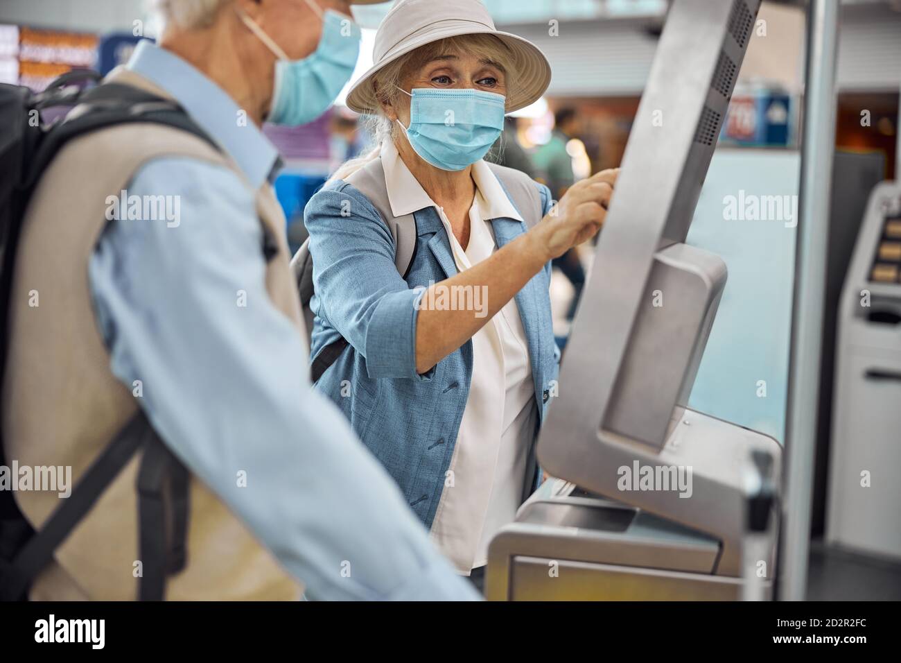 Elderly tourist couple checking in before boarding Stock Photo - Alamy