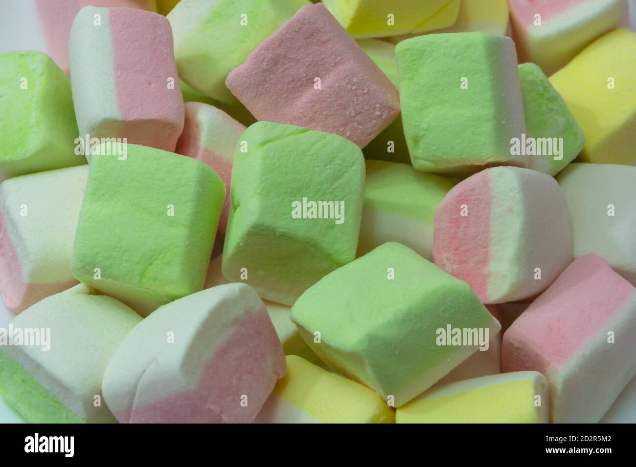 Marshmallow close-up. Pink, green and yellow dessert color. Light ...