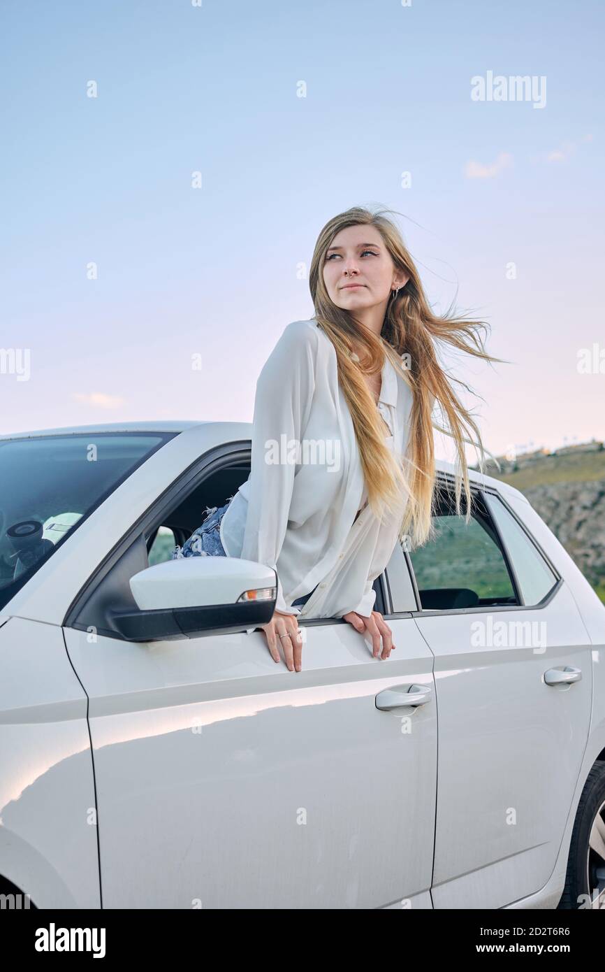 Carefree female driver looking out of window of automobile and enjoying ...