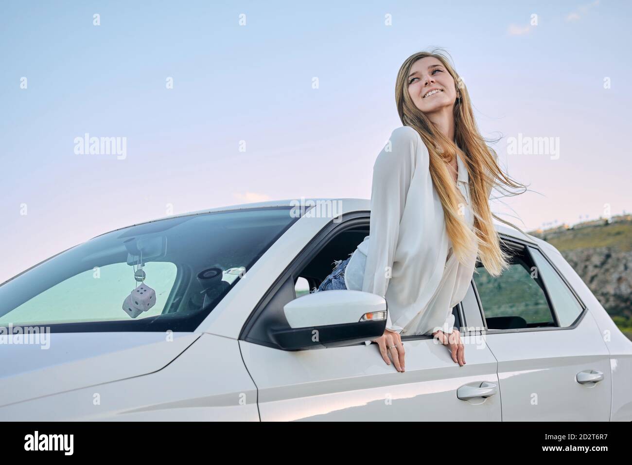 Carefree female driver looking out of window of automobile and enjoying ...