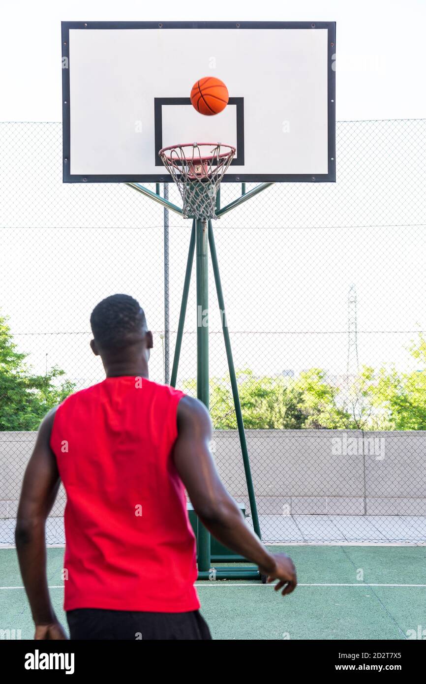 Back view of unrecognizable African American male playing basketball on ...