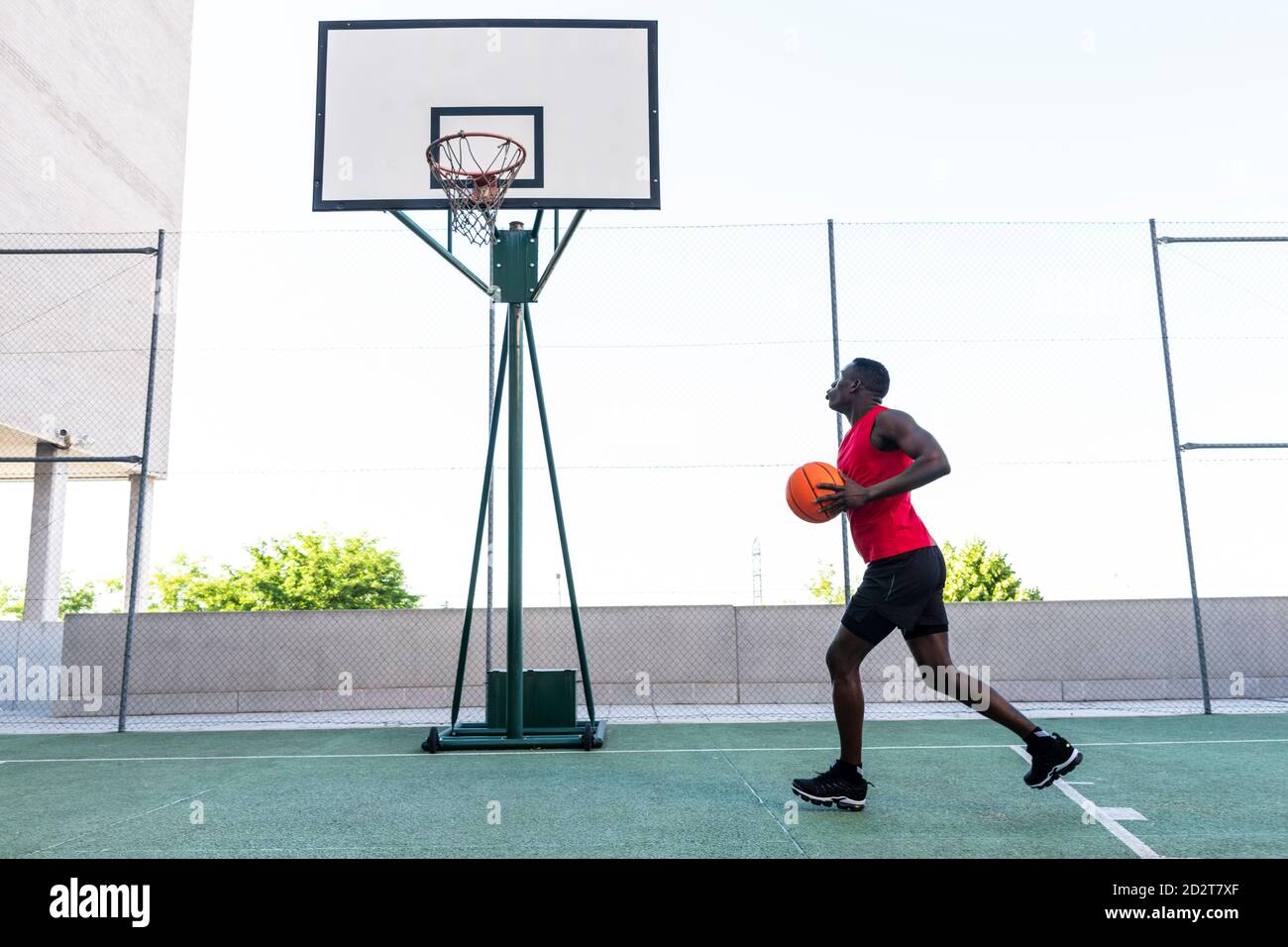Side view of African American sportsman jumping while playing ...