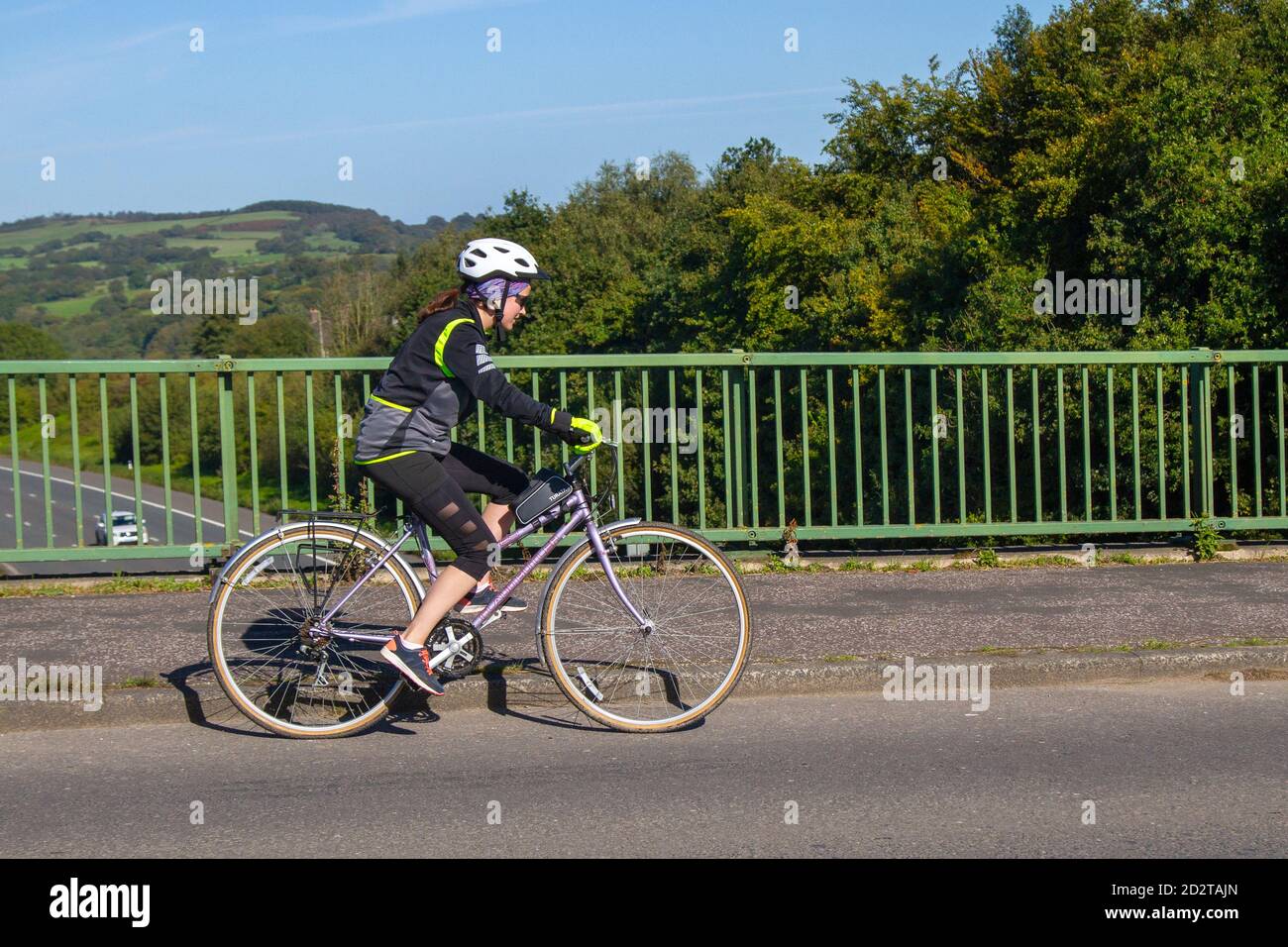 Female cyclist riding pink Claude Butler sports road bike on ...